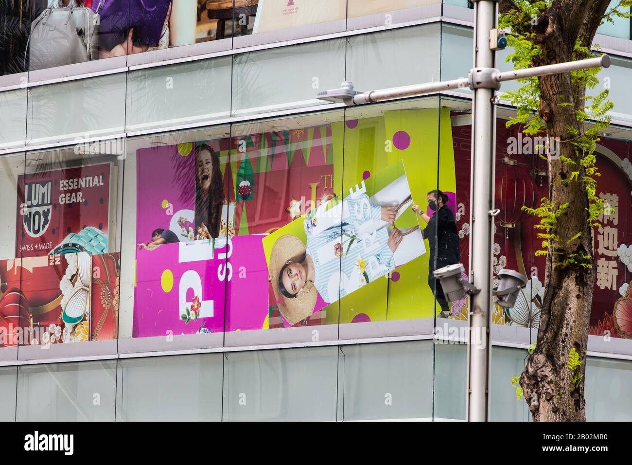 Retail staffs is changing advertisement graphics panel/board on the ...