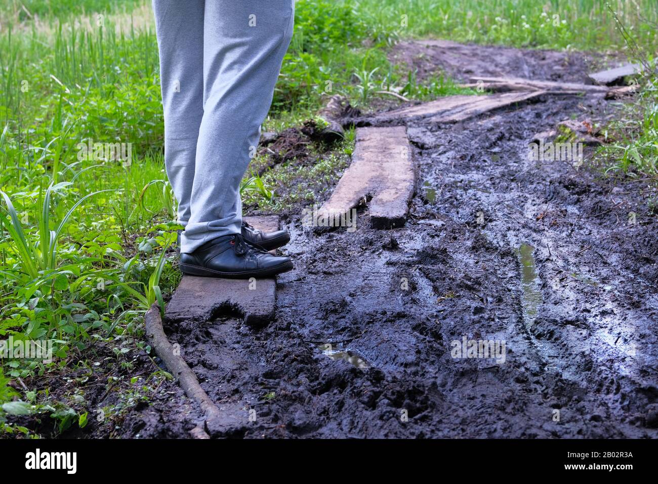 Man walk along the forest trail. Forest muddy road. Dirt track ...