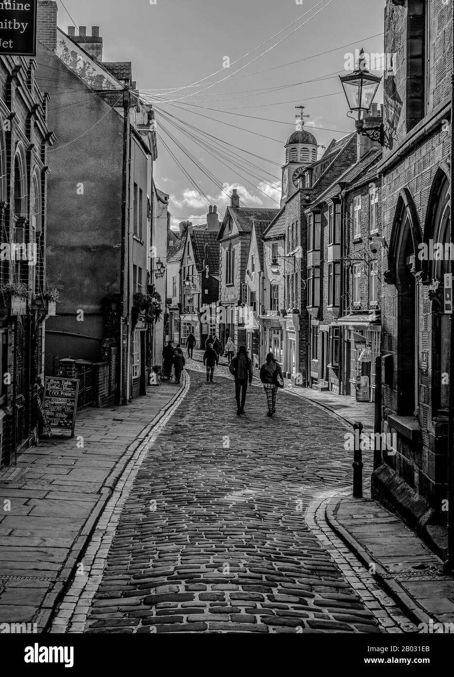 An old, quaint, street in Whitby. The cobbled street winds between rows ...