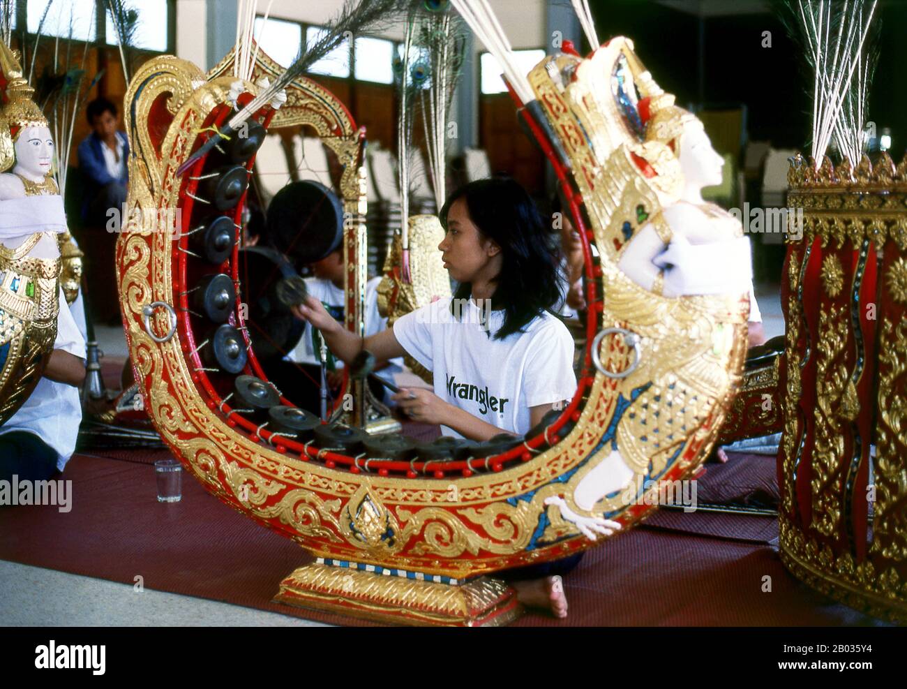 Thailand: A young woman plays the khong mon, a gong-circle instrument ...