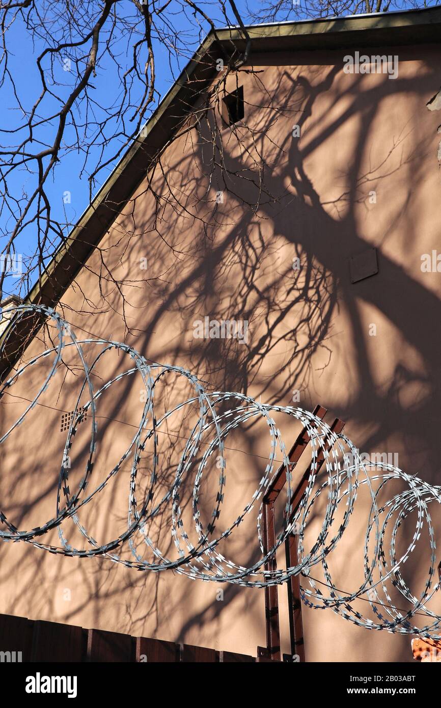 Barbed wire fence over the entrance of a building Stock Photo - Alamy