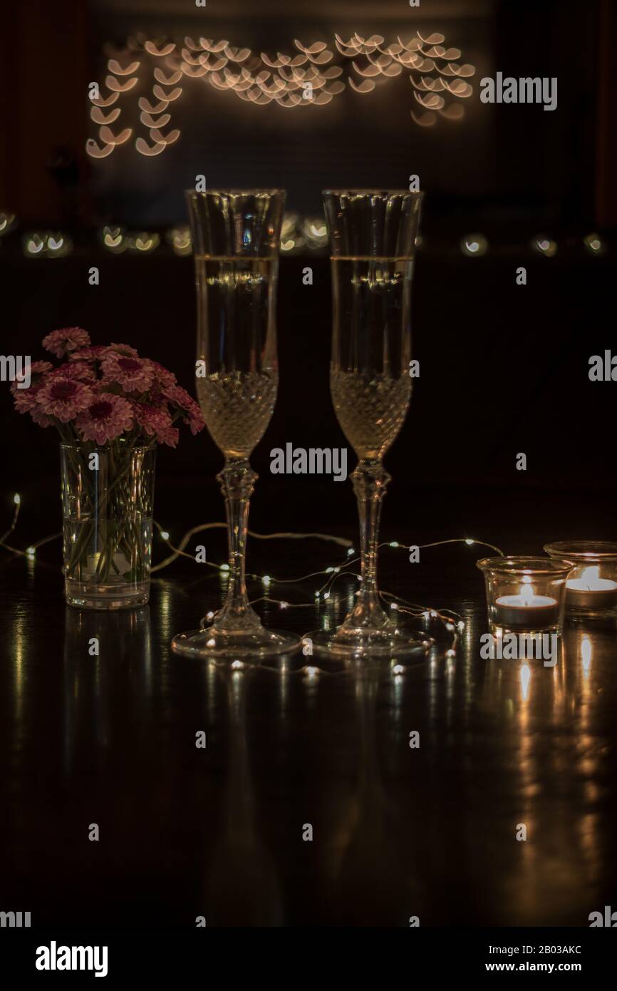 Champagne and roses on dark table for romantic dinner date night heart ...