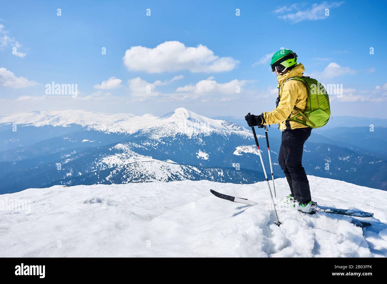 Man on ski on the summit enjoys spectacularly view mountain landscape ...