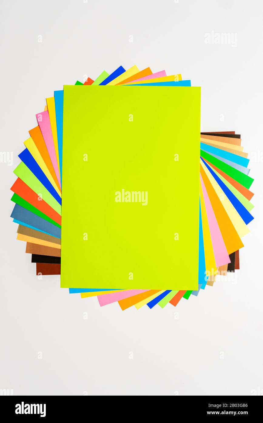 a stack of of color paper sheets on the table flat lay, view from above ...