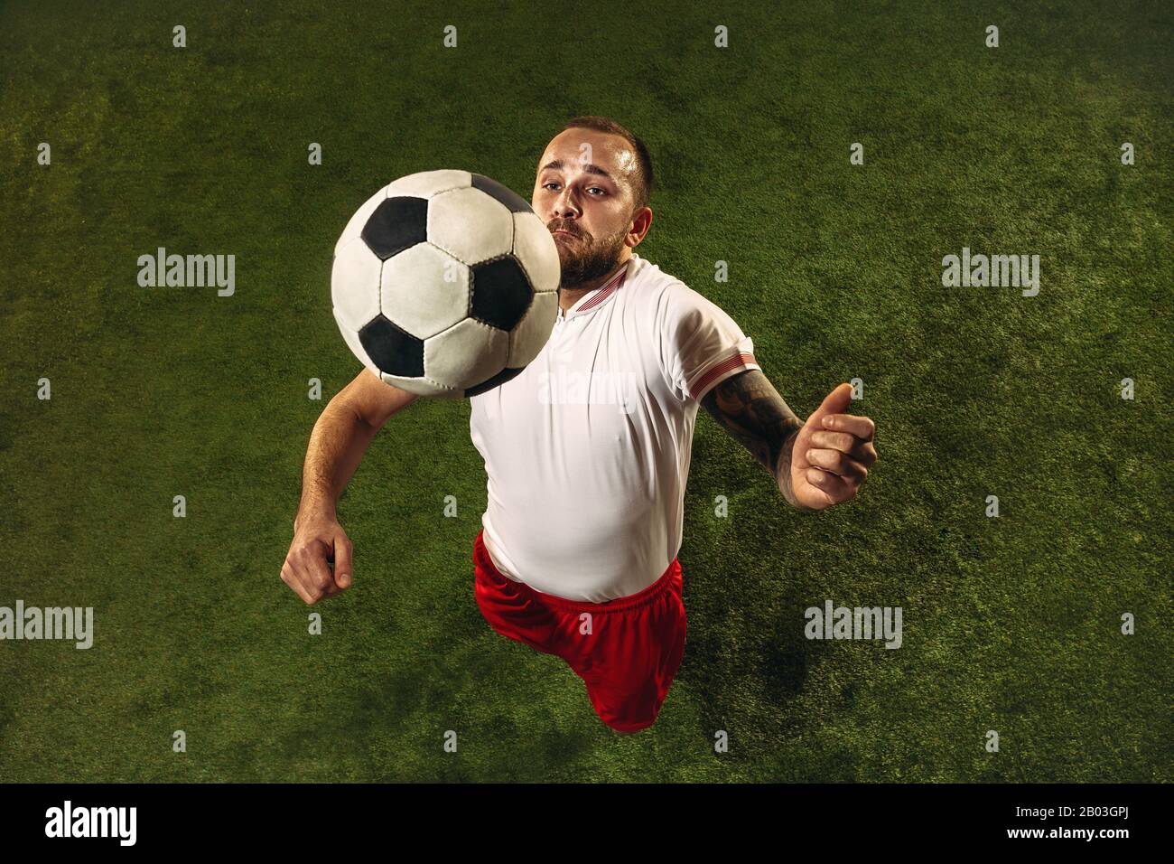 Top view of caucasian football or soccer player on green background of ...