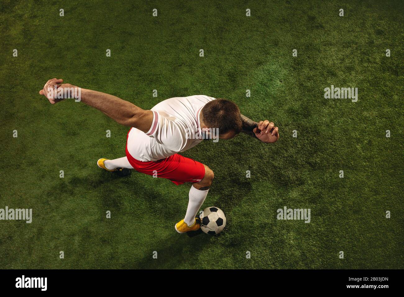 Top view of caucasian football or soccer player on green background of ...