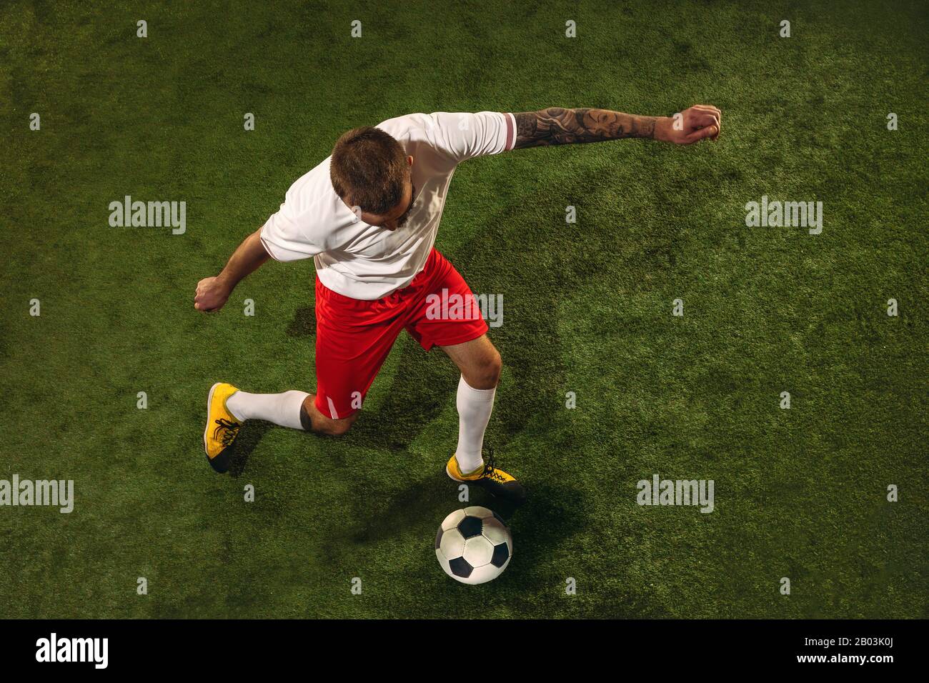 Top view of caucasian football or soccer player on green background of ...