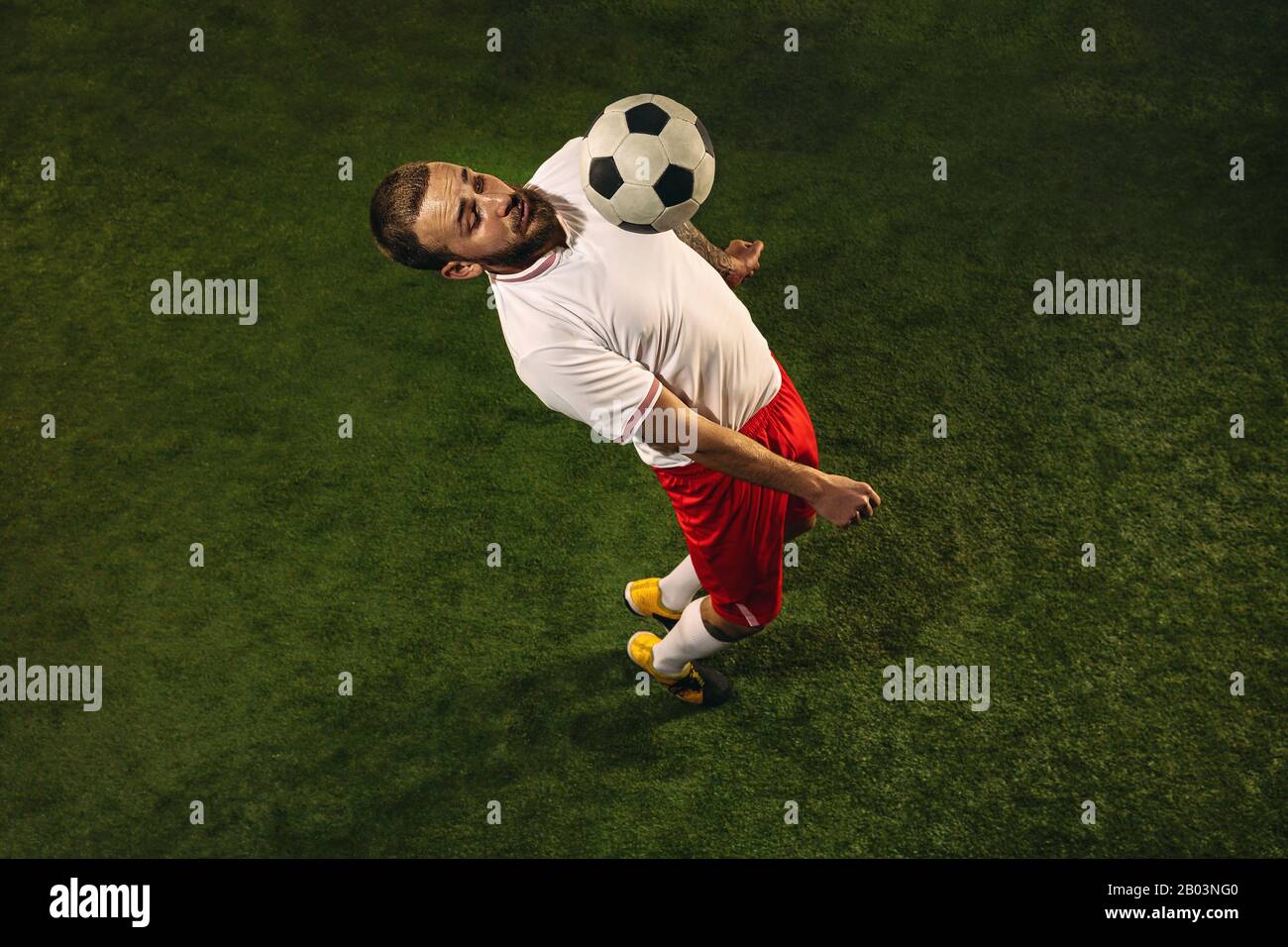 Top view of caucasian football or soccer player on green background of ...