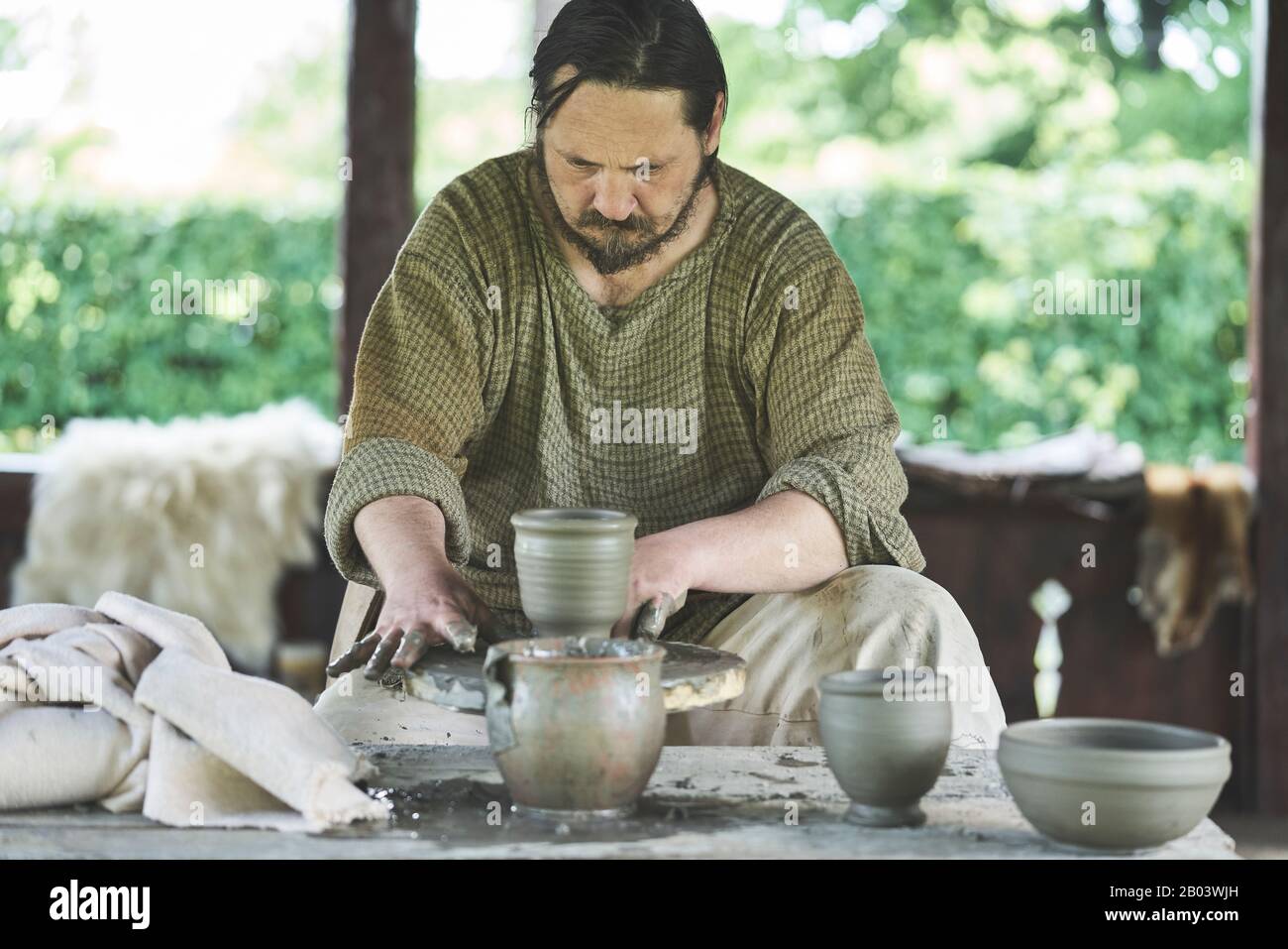Traditional potter using ancient Dacian method on a foot-powered clay ...