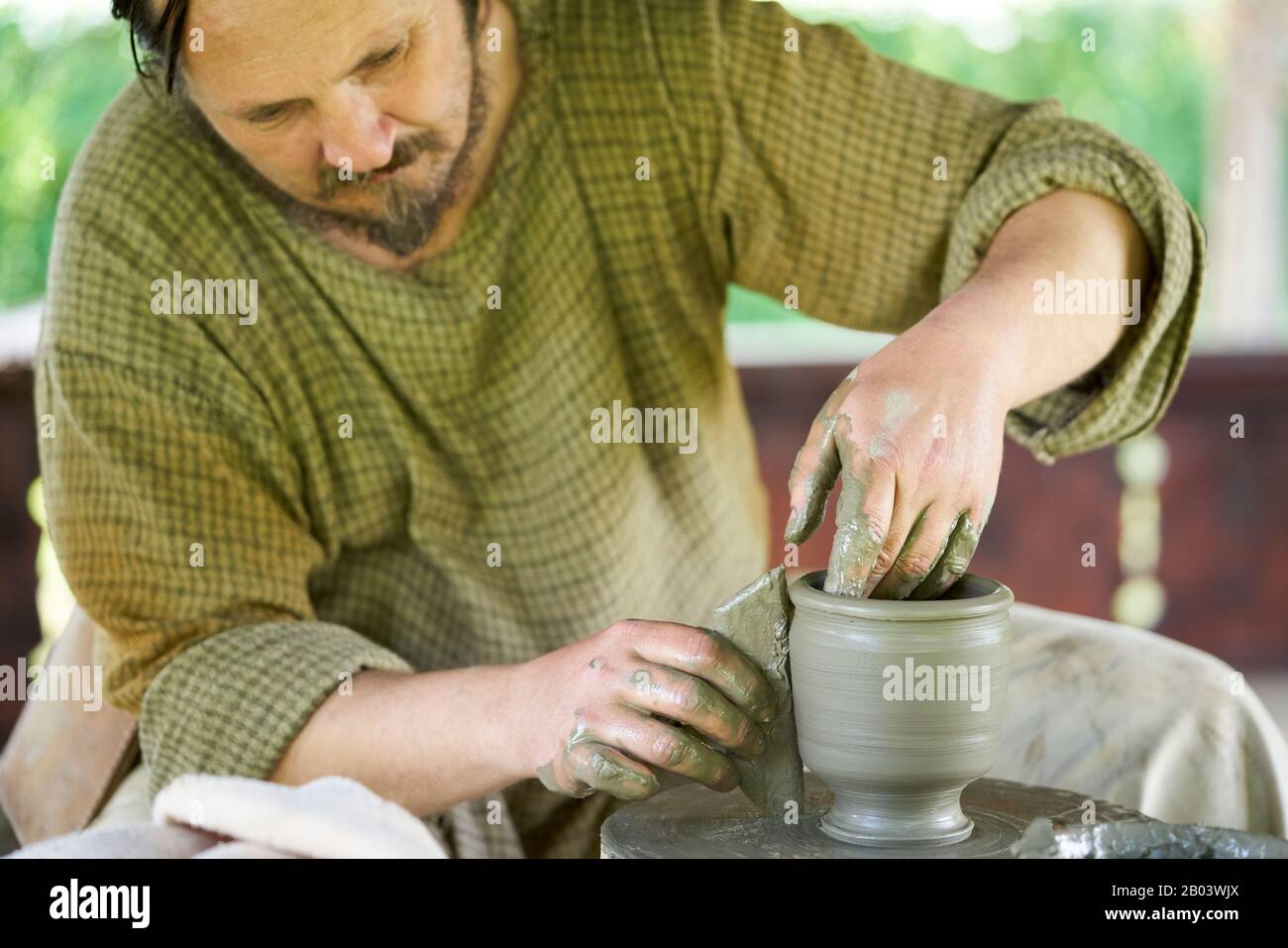 Traditional potter using ancient Dacian method on a foot-powered clay ...