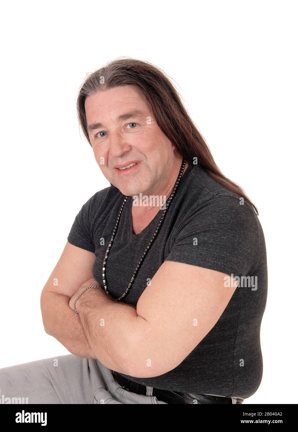 A happy indigenous man sitting for a portrait image on a chair with his ...