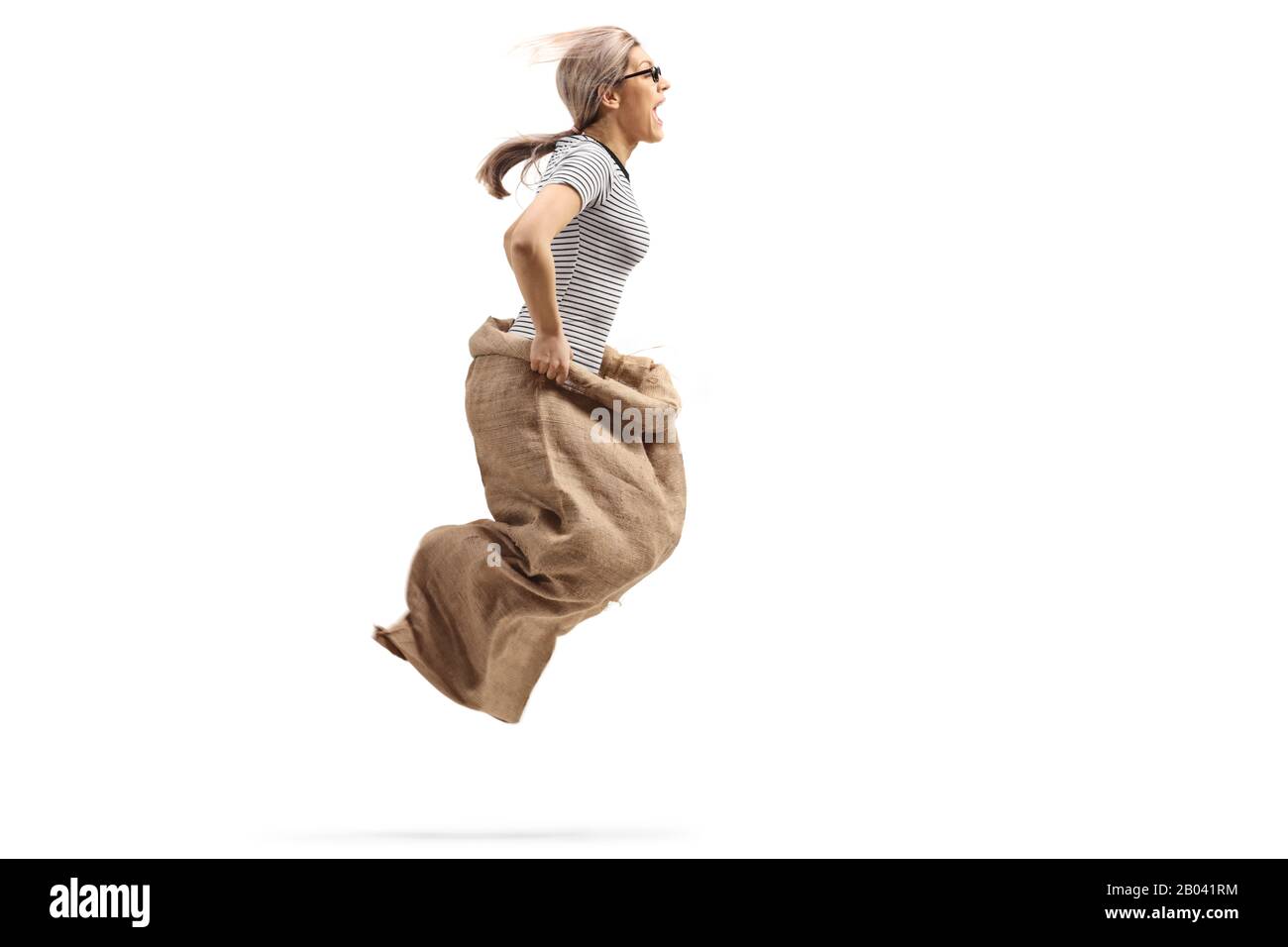 Excited young woman jumping in a sack isolated on white background ...