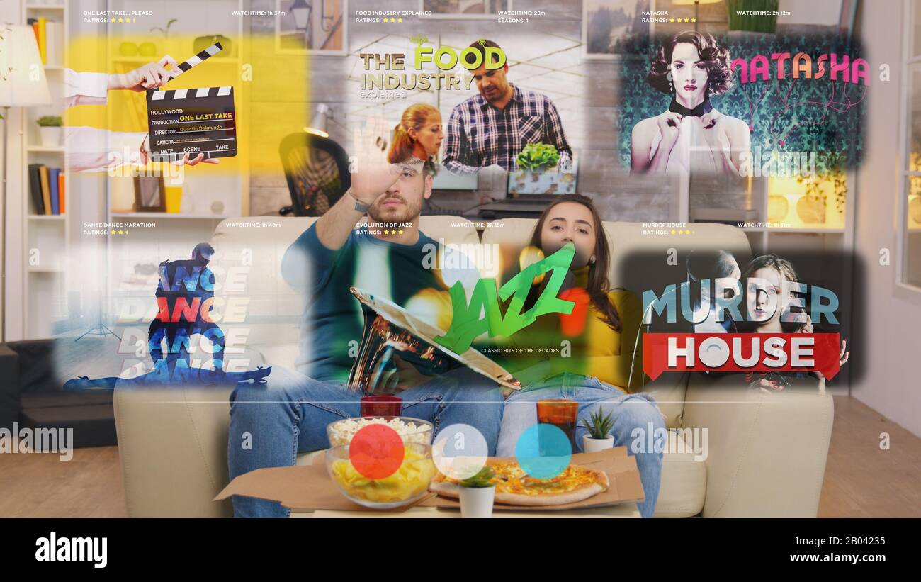 Couple on the couch watching a virtual projection of a smart TV in ...