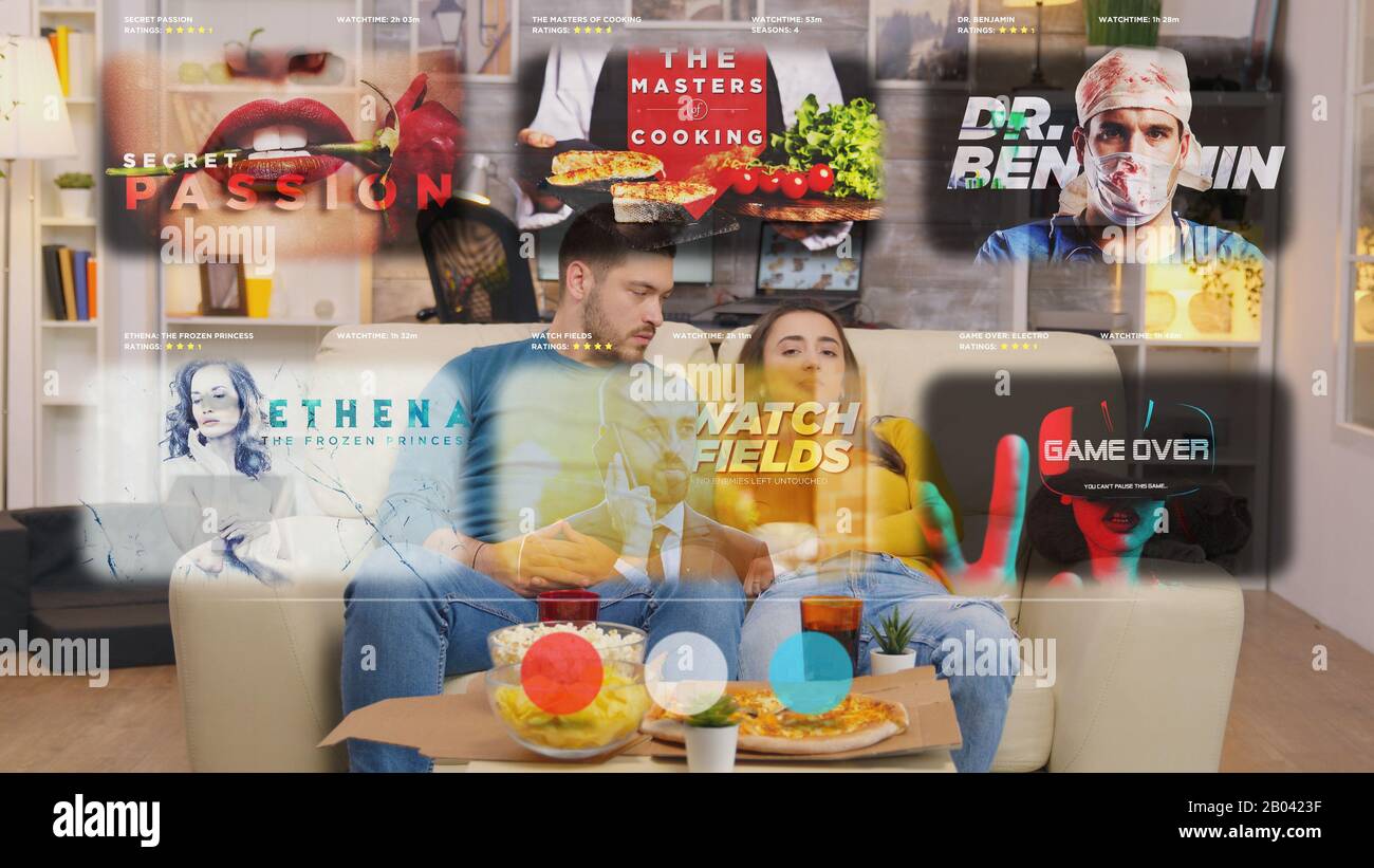 Couple on the couch watching a virtual projection of a smart TV in ...
