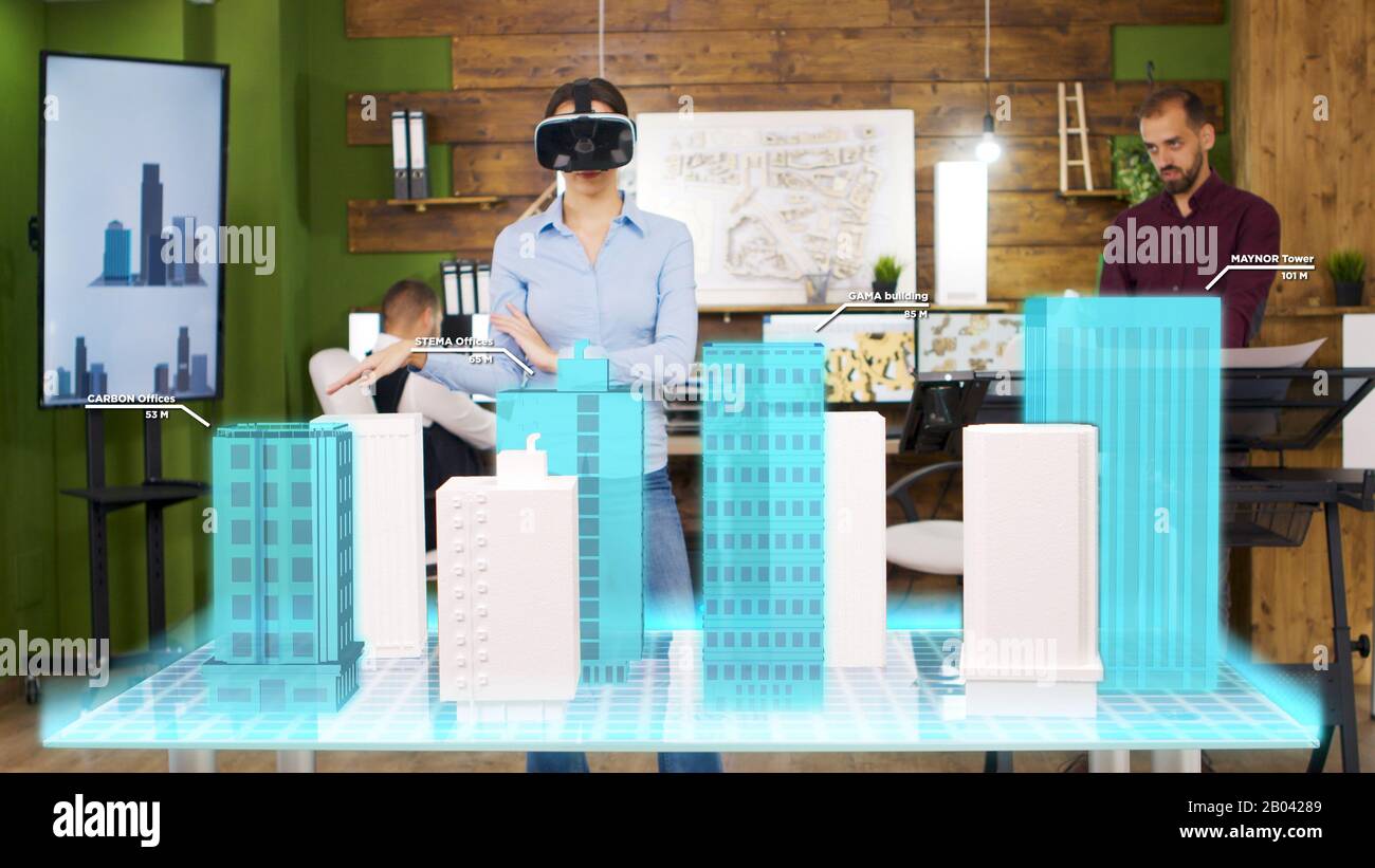 Architect woman wearing VR headset is looking at holographic ...