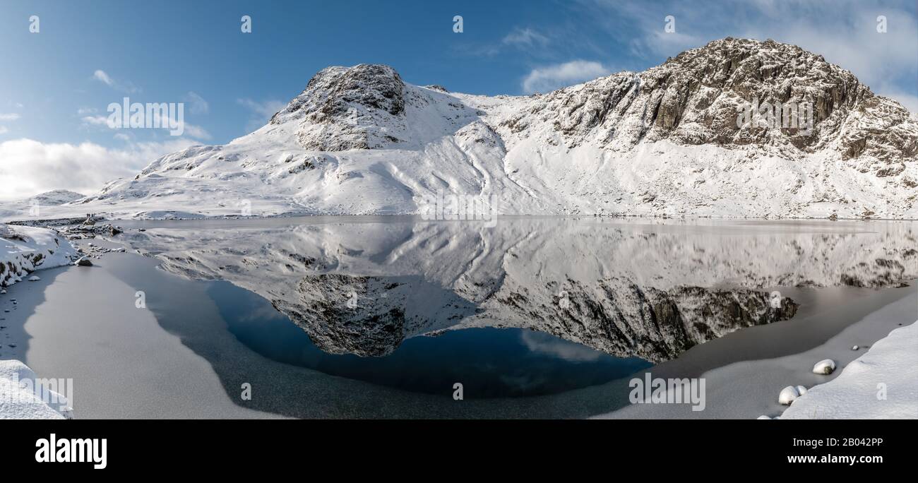 Snow-covered Harrison Stickle and Pavey Arc reflected in a partially ...