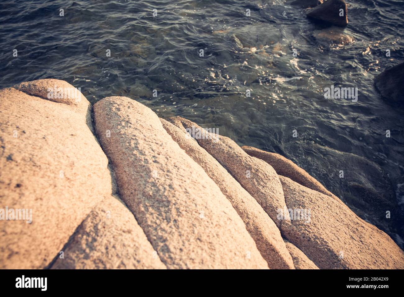 Pile of stones and the sea behind / Beautiful coast in Greece while sun ...