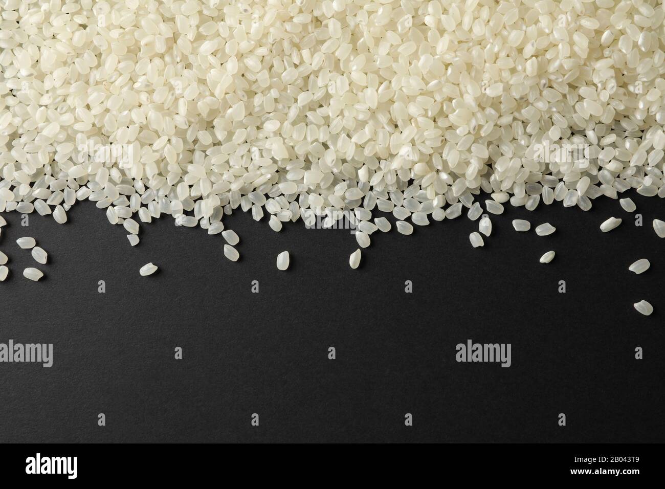 Rice on black background, top view and space for text Stock Photo - Alamy