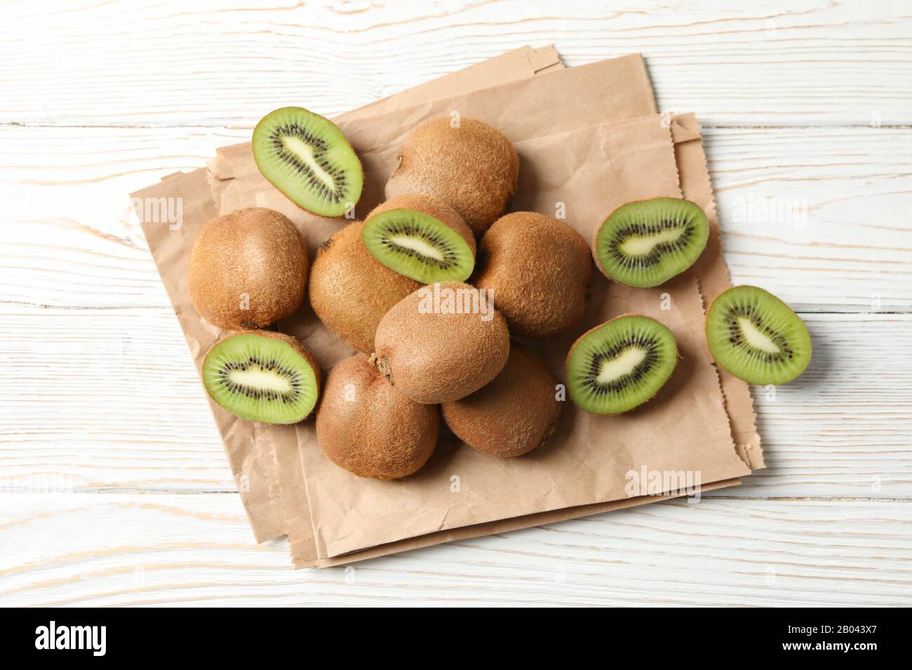 Craft paper with kiwi on wooden table, top view Stock Photo - Alamy
