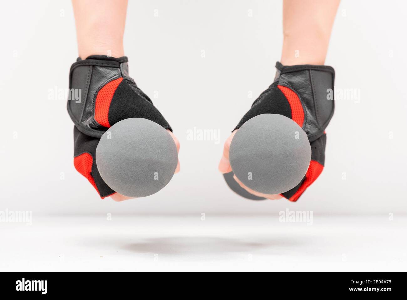 Female hands with a small dumbbells close up over white background ...