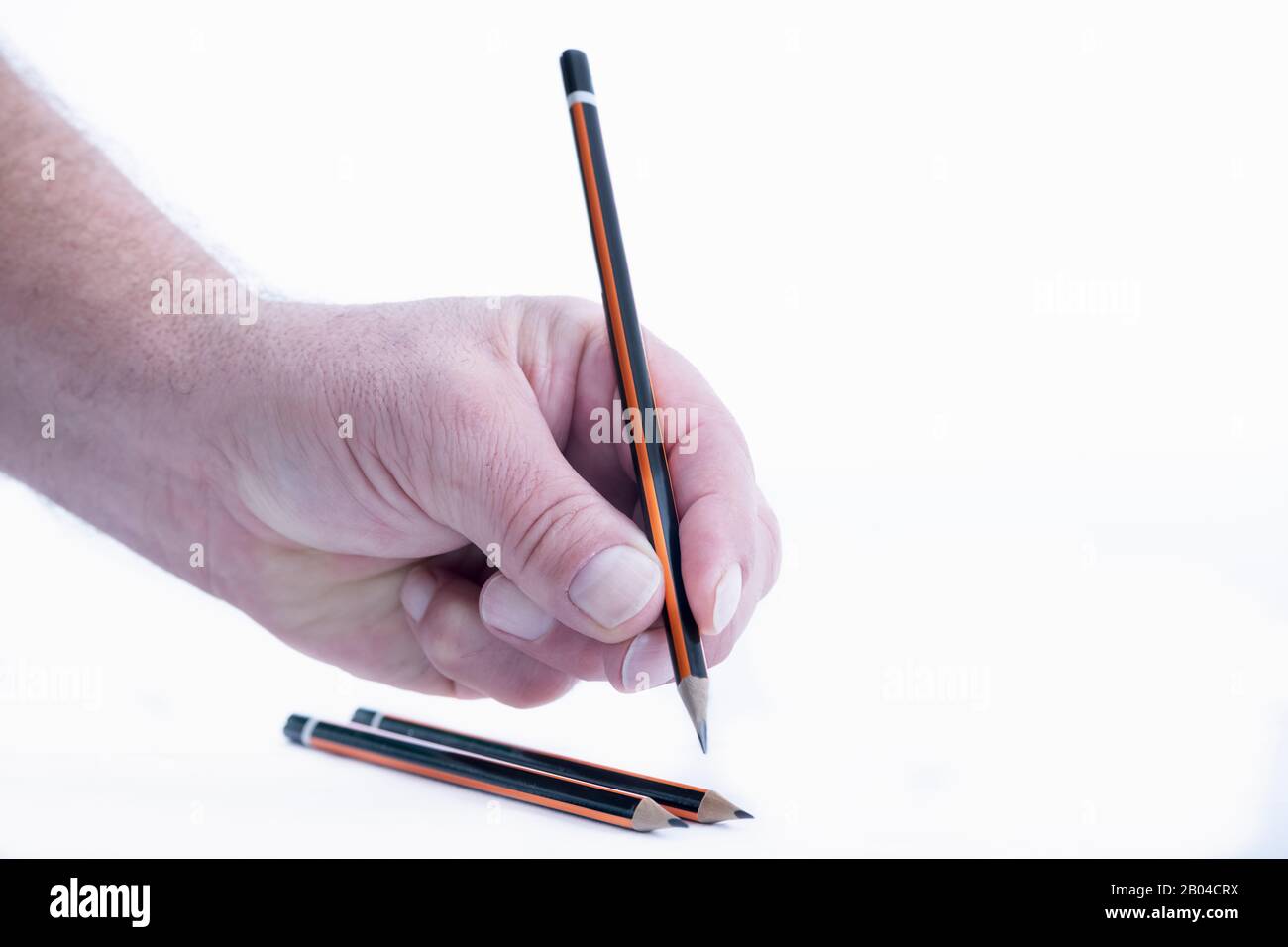Male hand holding pencil in a writing position Stock Photo - Alamy
