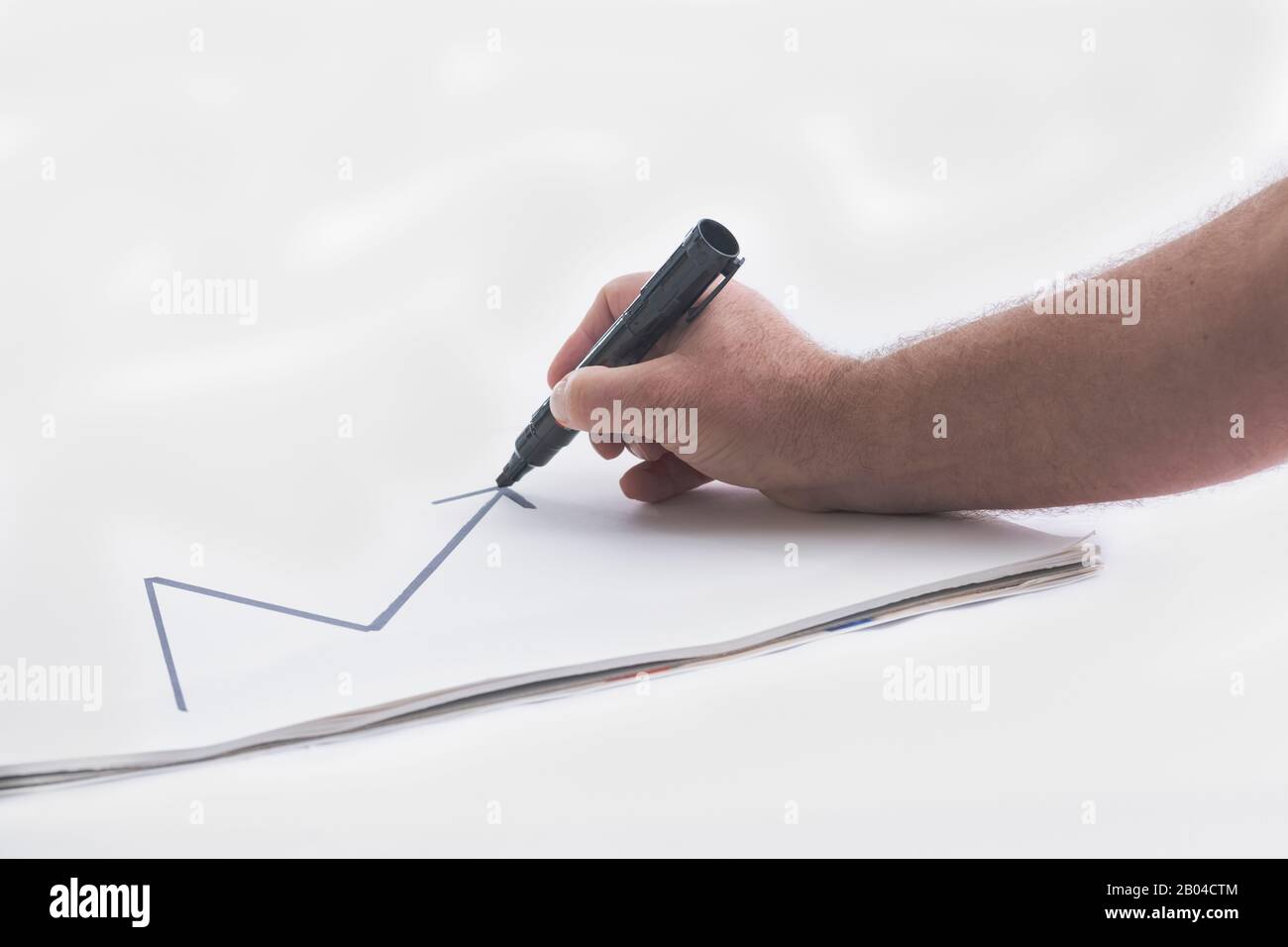 Male hand drawing an upwards line on paper Stock Photo - Alamy