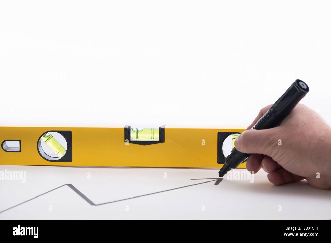 Male hand drawing a line next to a bubble level tool Stock Photo - Alamy