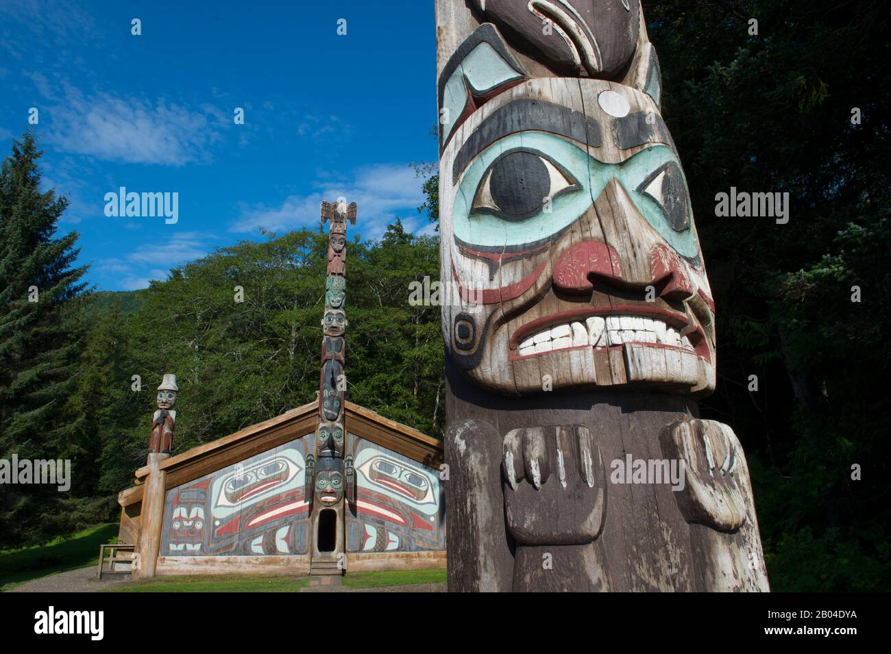 Tlingit totem pole with clan house in the background at the Totem Bight ...