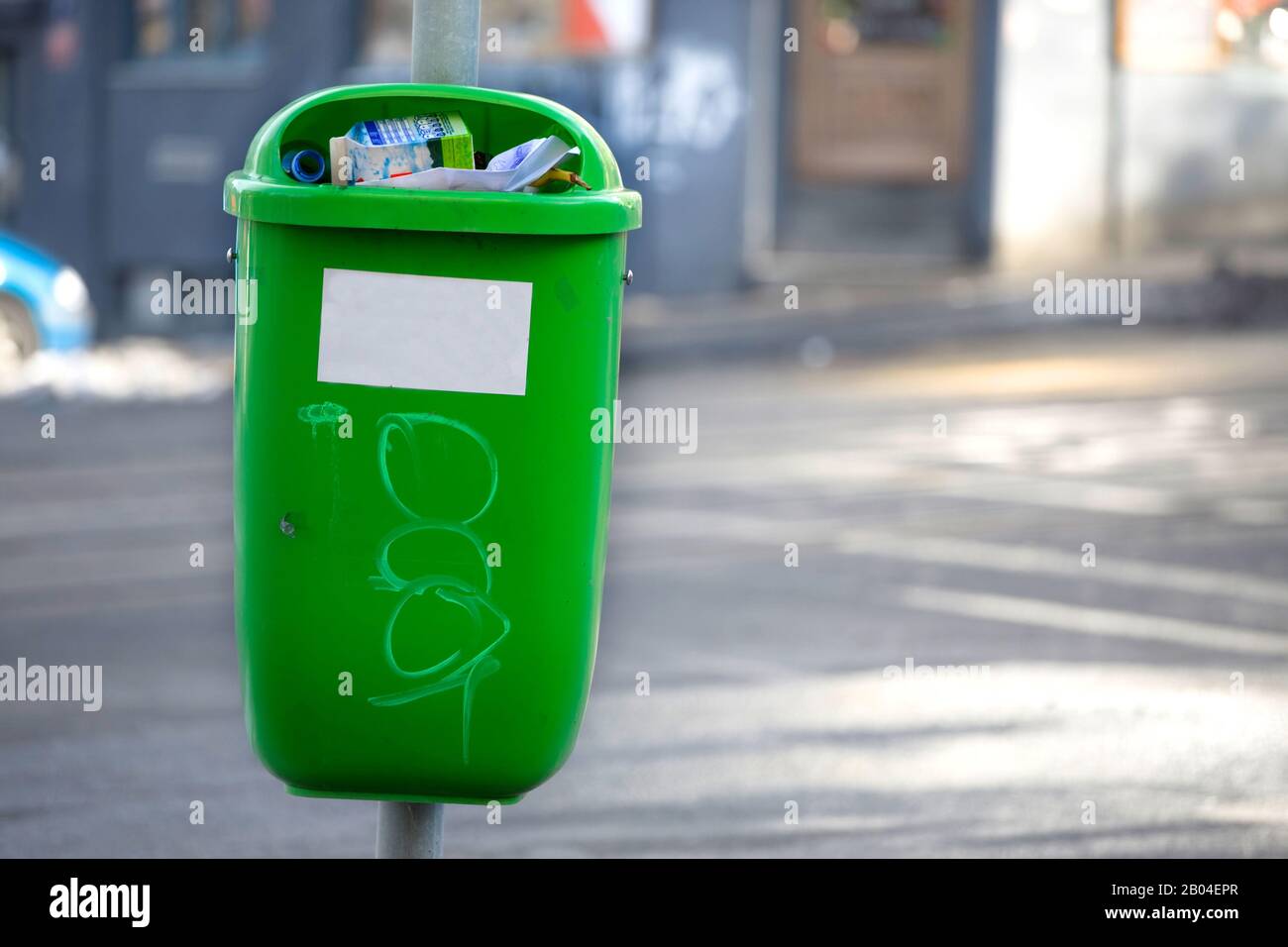 Green trash bin filled with trash in a city environment Stock Photo - Alamy