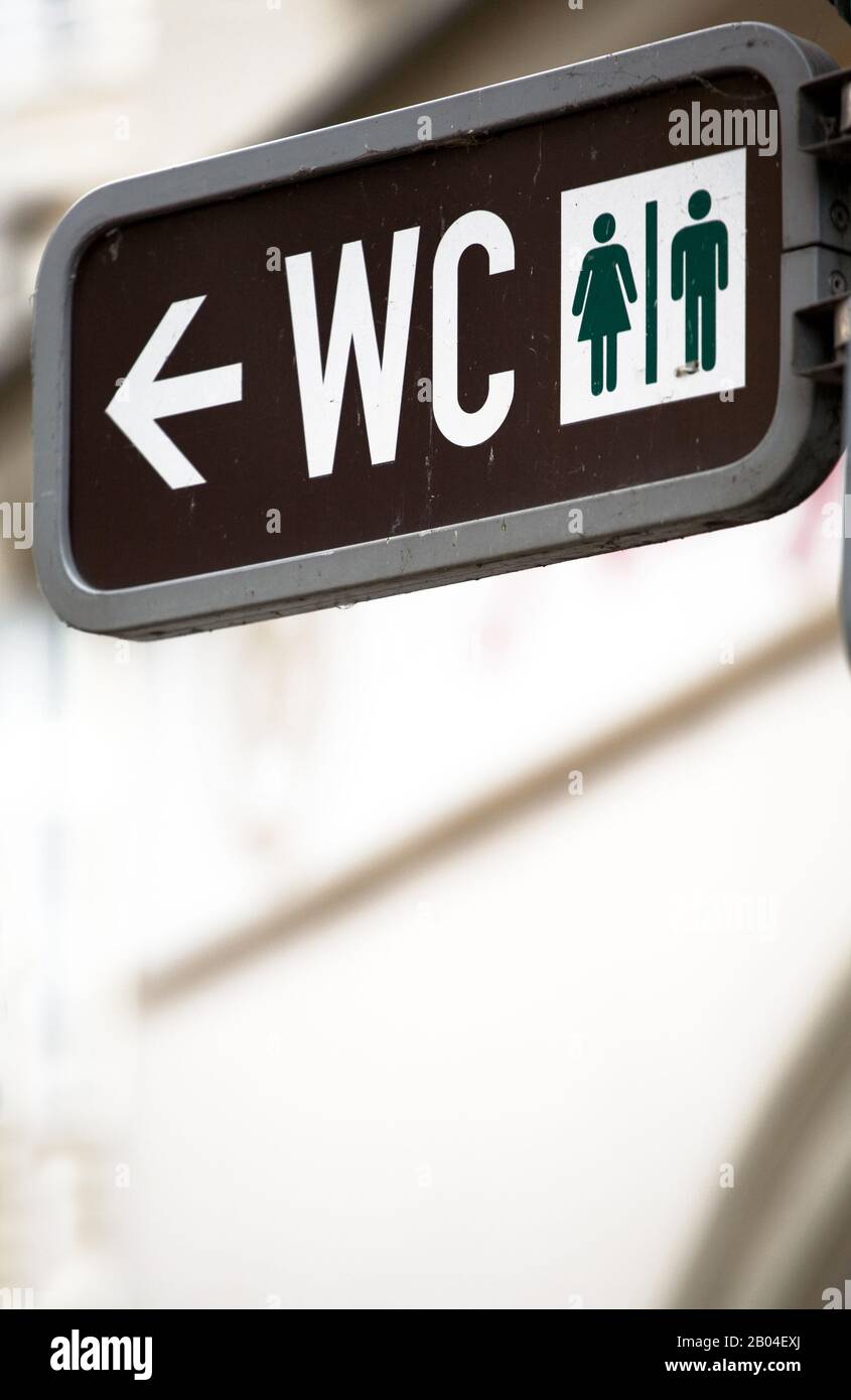 Unisex toilet sign hinged on a post Stock Photo - Alamy