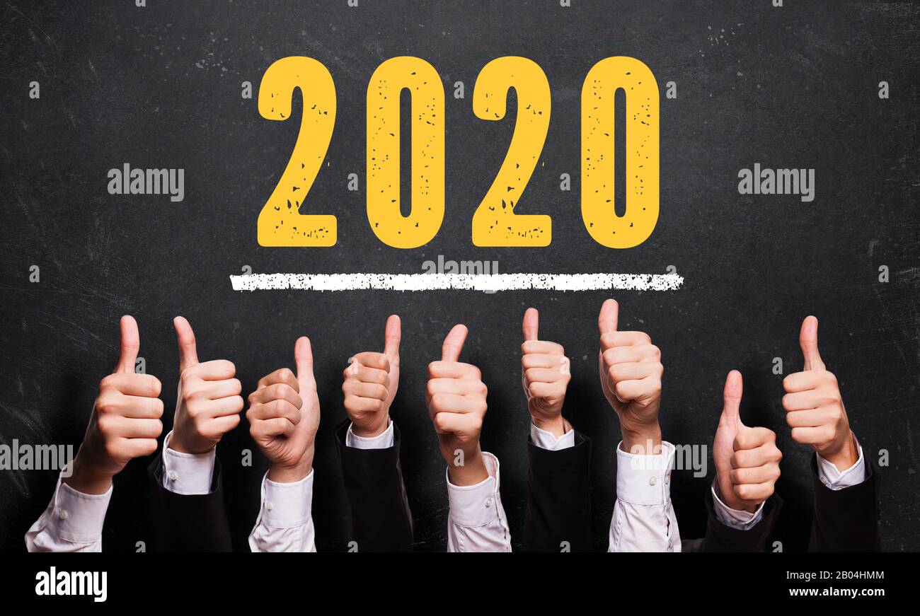 many thumbs up in front of blackboard with message 2020 Stock Photo - Alamy