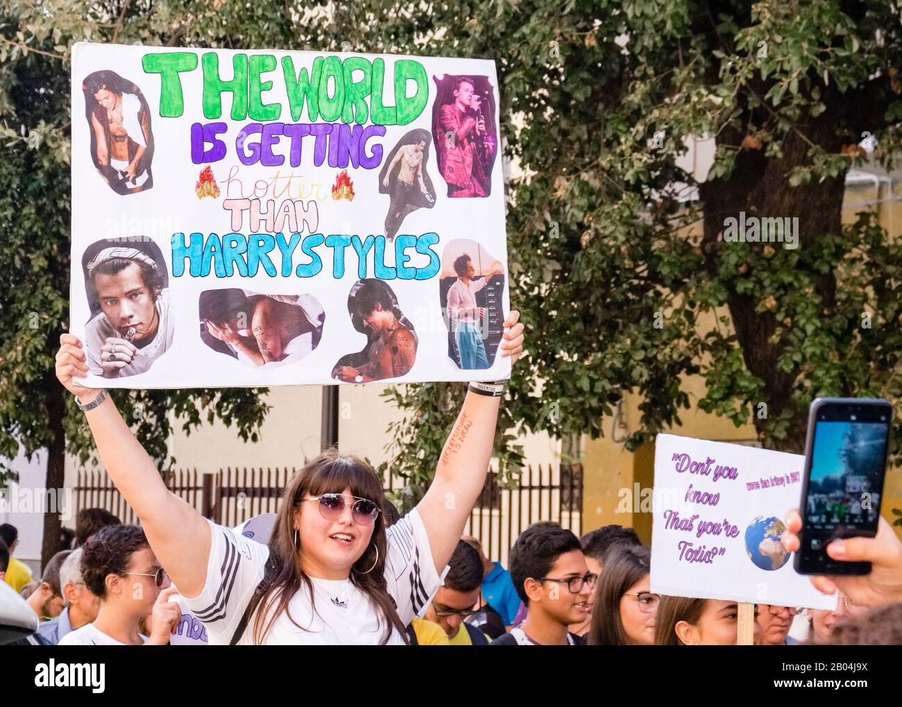 Young girl protests against climate change by showing a sign with ...