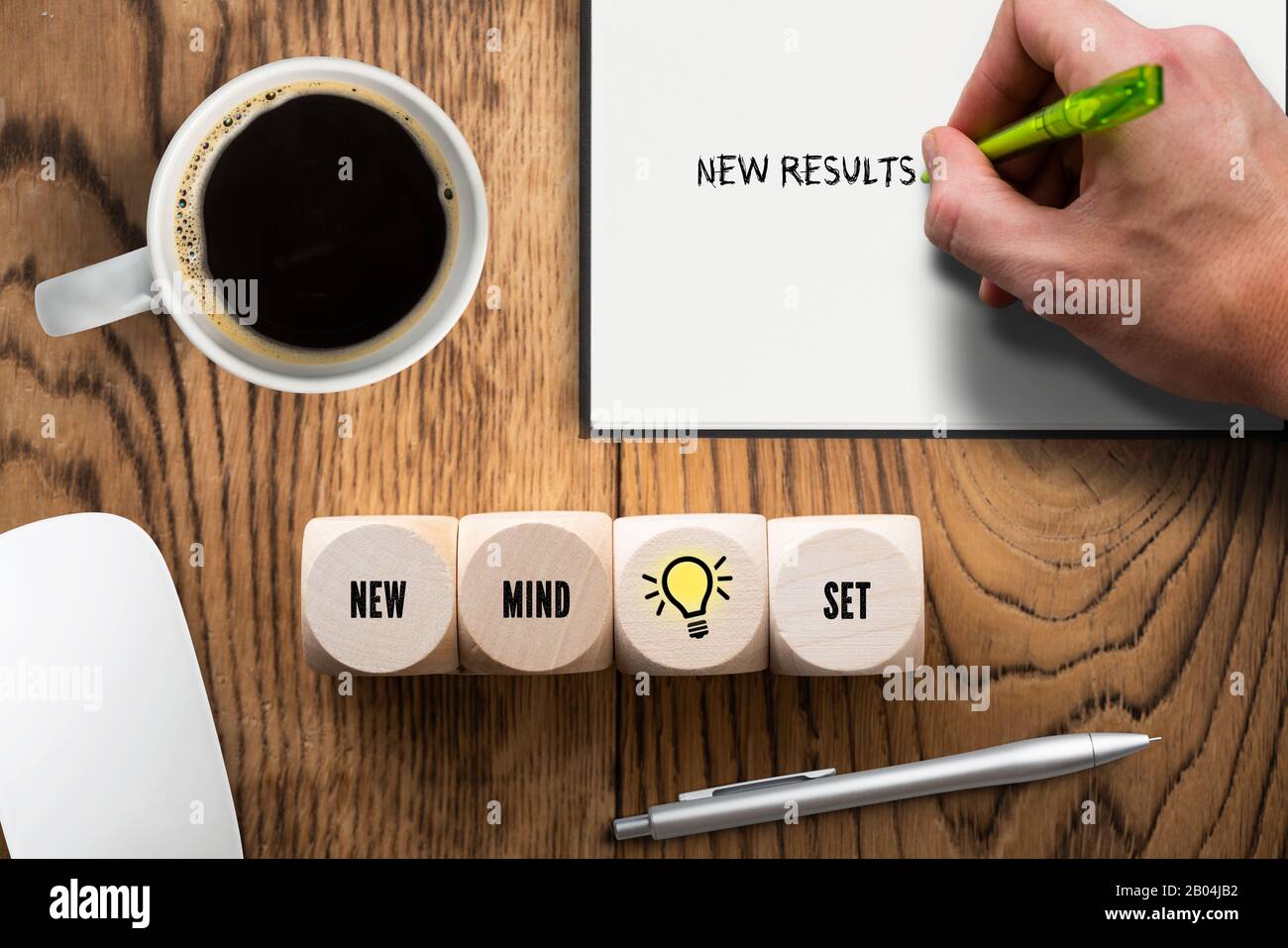 cubes with words and hand with pen writing the message "new mindset ...