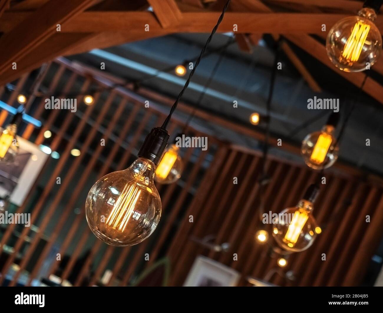Photo tilted at close range of decorative bulb lights hanging in a cafe ...