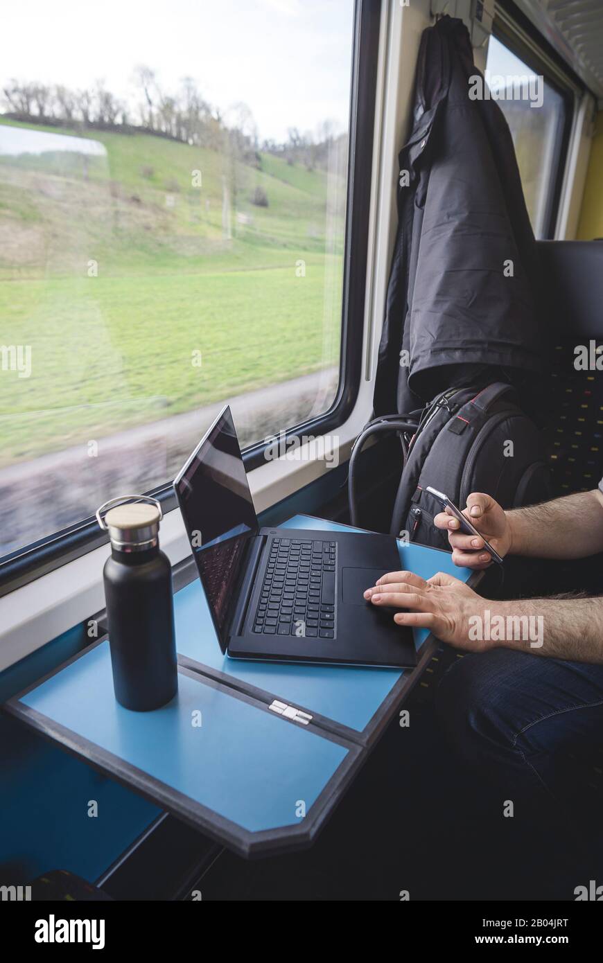 Man working on a laptop on train travel. Swiss train interior with ...