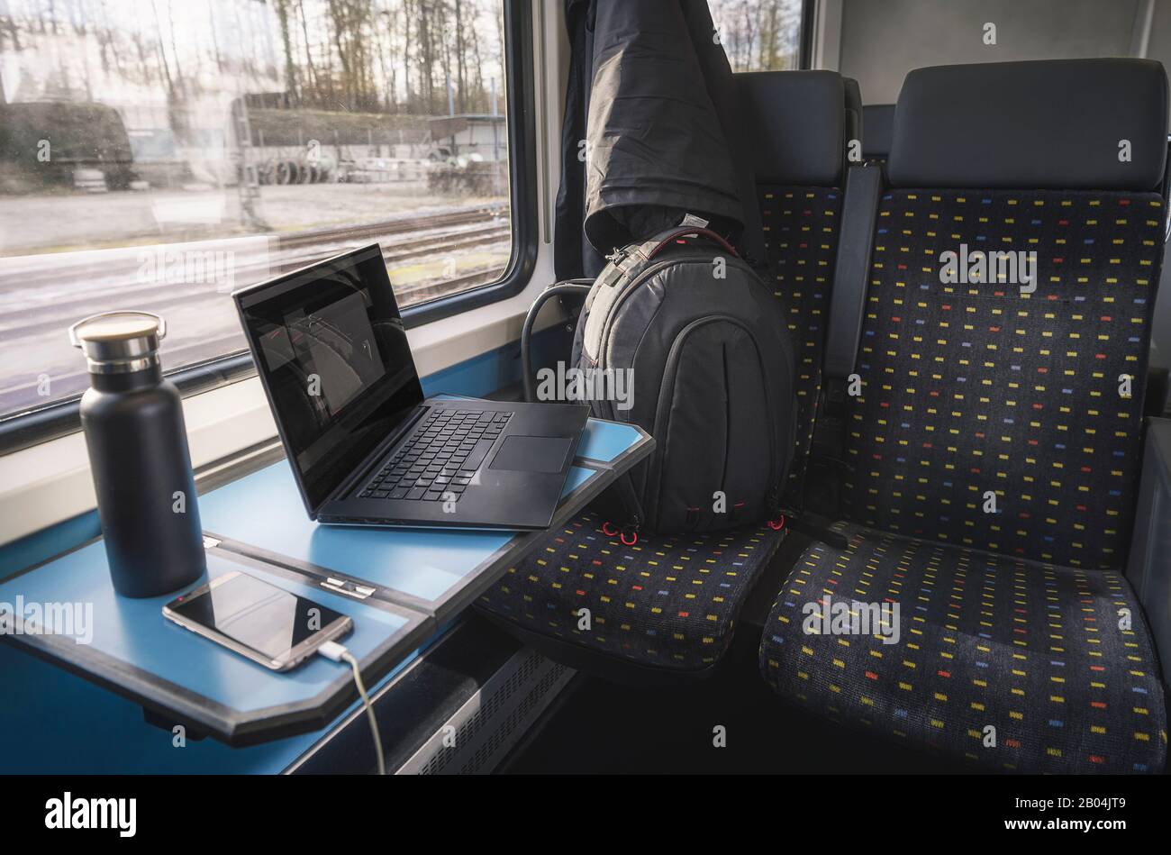 Train interior with comfortable chairs, a table, and a window view ...