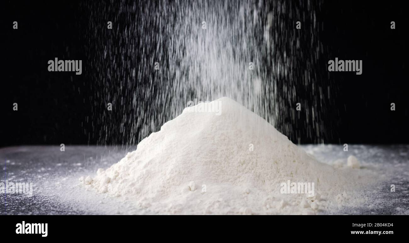 Pile of white flour falling on black background Stock Photo - Alamy