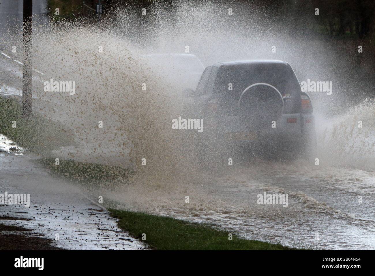 a 4x4 vehicle driven at speed through flood water causing a large ...