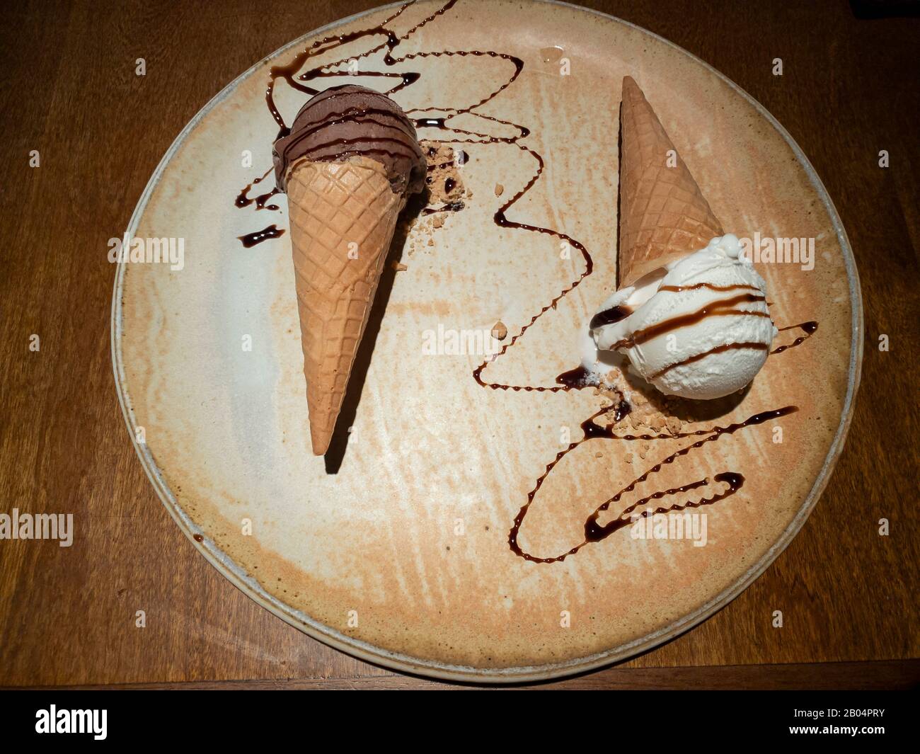 Two ice cream cones with chocolate and cream Stock Photo - Alamy