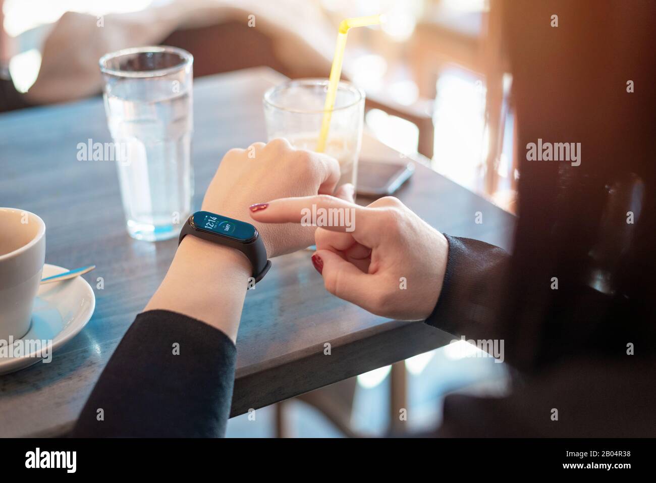 Girl touch smart band, bracelet screen on her arm. Displayed ime and ...