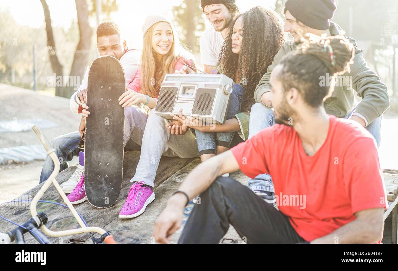 Happy generation z friends listening music and laughing in city park ...