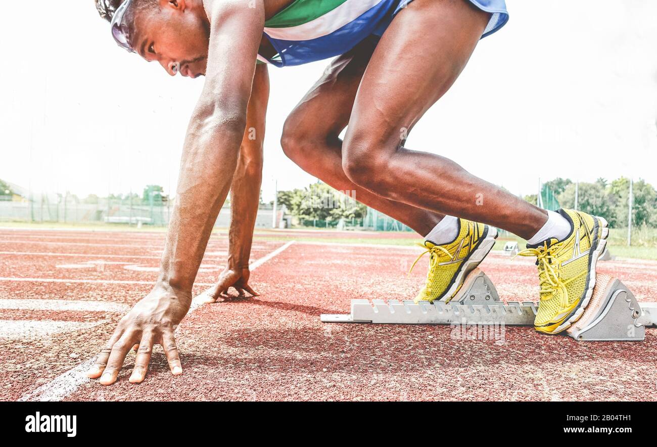 Afro american runner using starting block to start his run on race ...