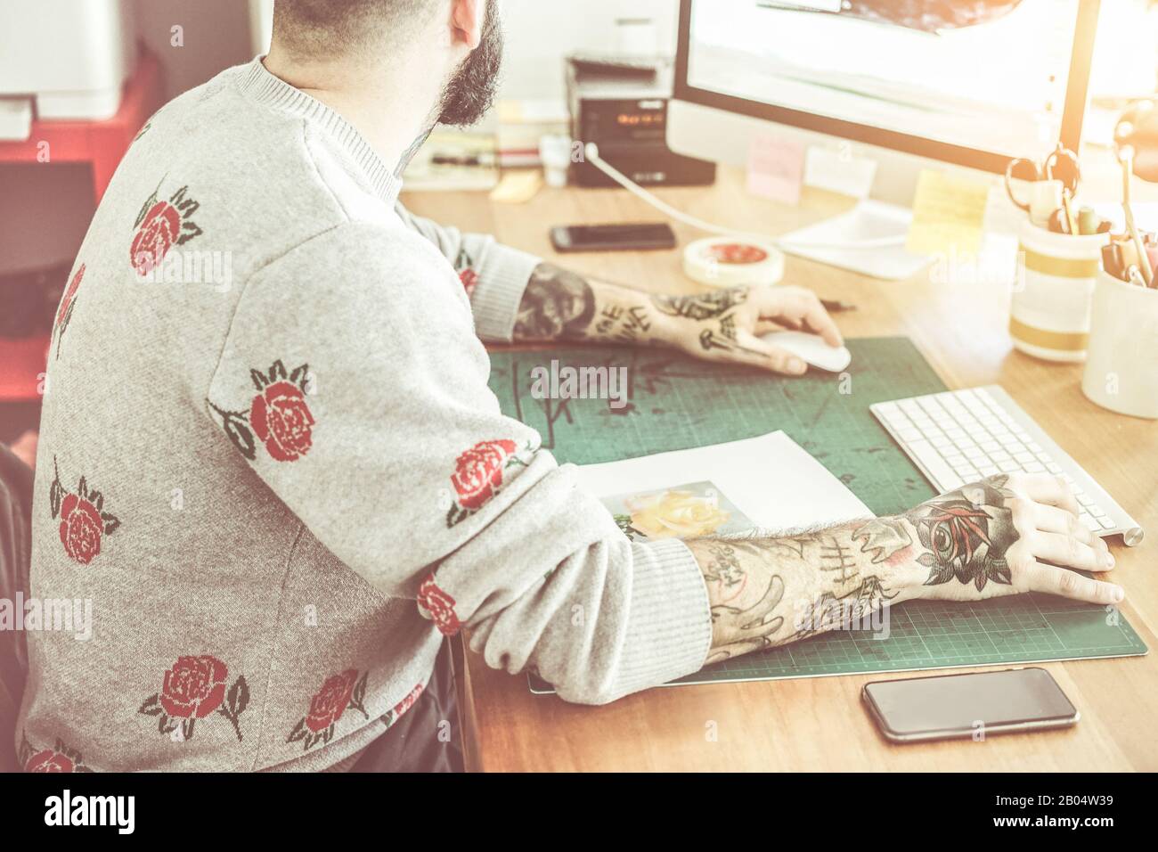 Tattoo artist creating new illustration with computer inside ink studio ...