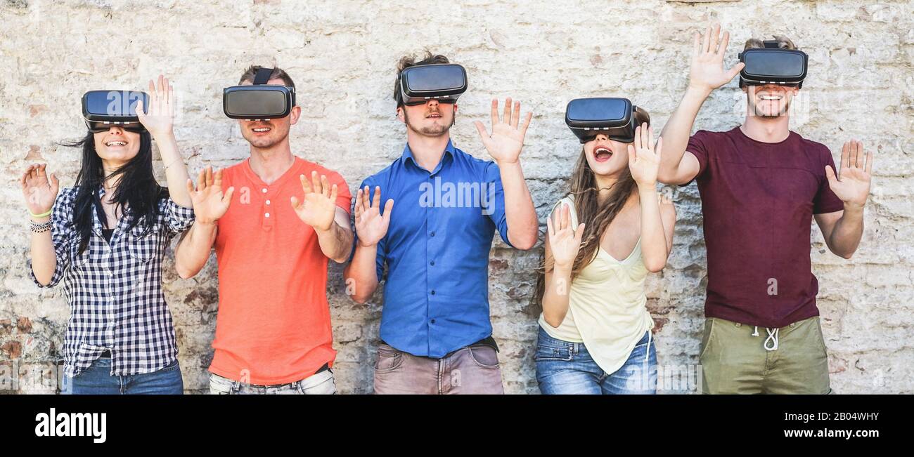 Young students wearing virtual reality glasses outdoor - Happy people ...