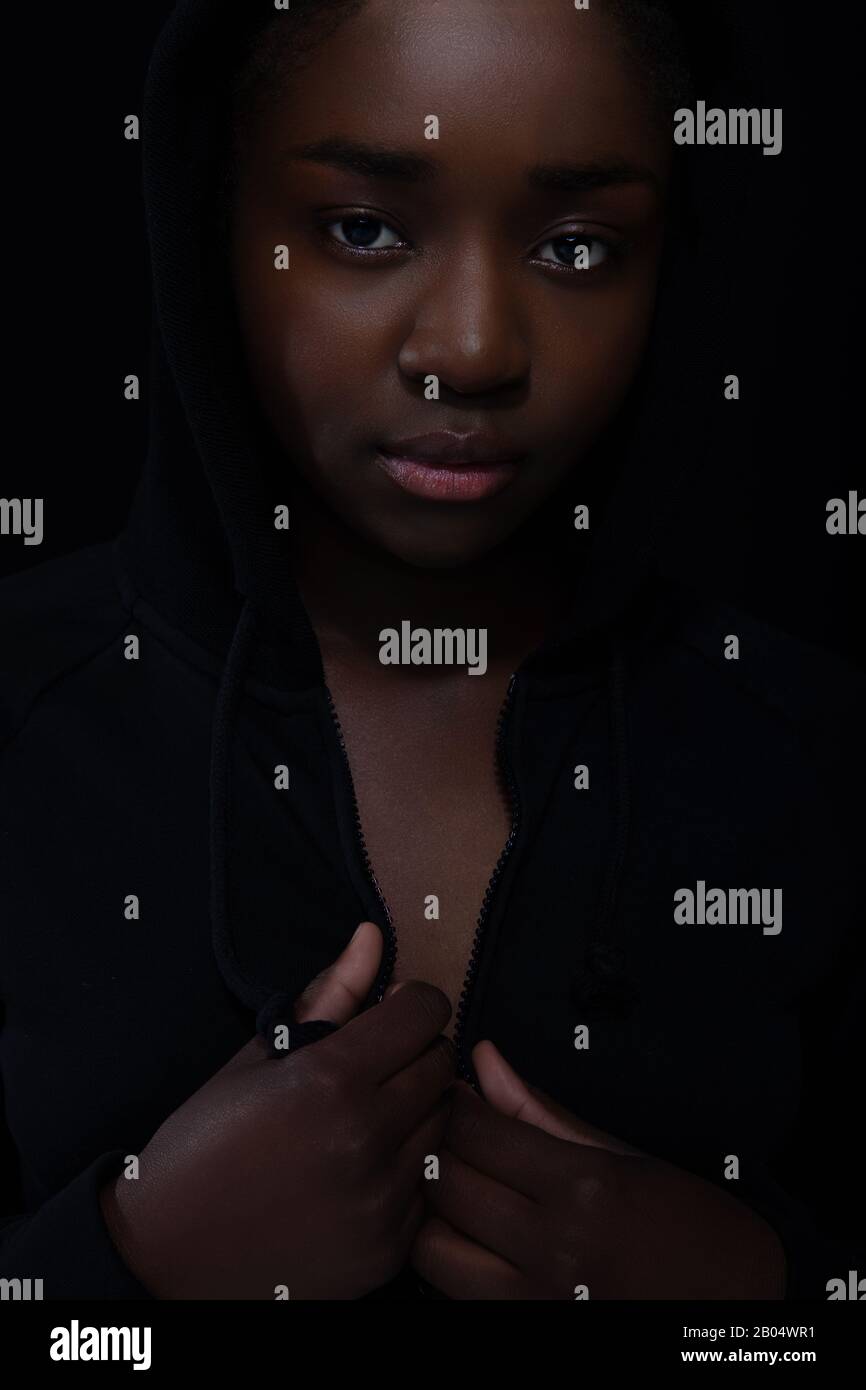 Cool and reticent woman with dark skin and attitude wearing hoodie ...