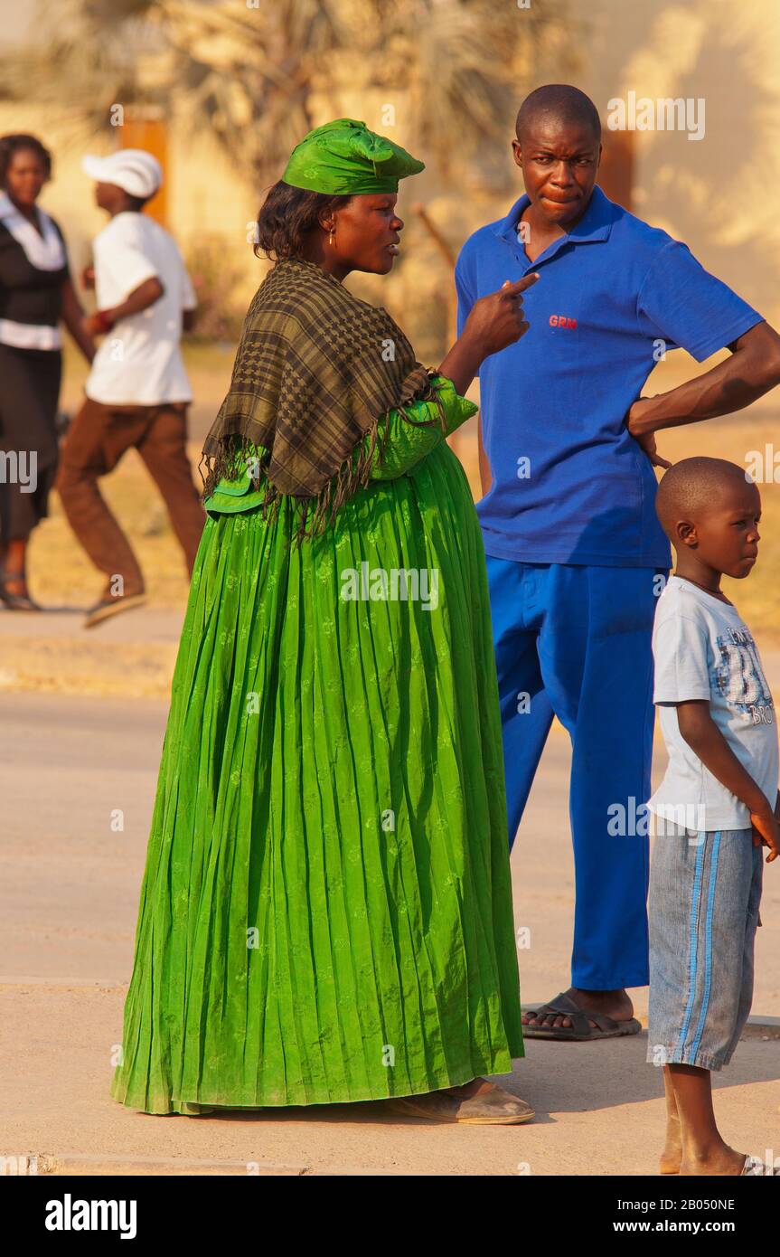 Herero woman in green traditional clothes walking on Outjo streets ...