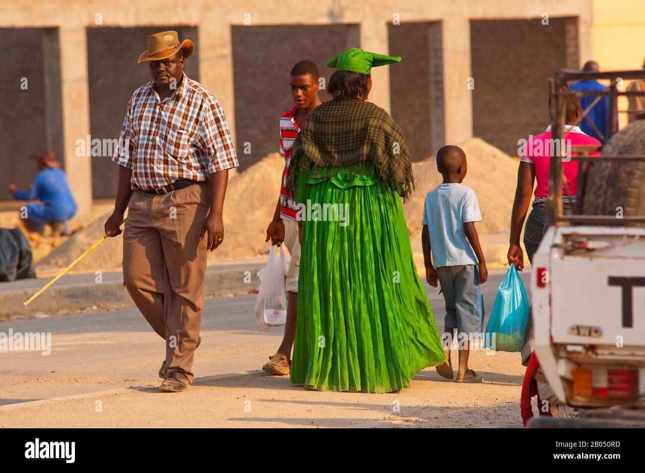 Herero woman in green traditional clothes walking on Outjo streets ...