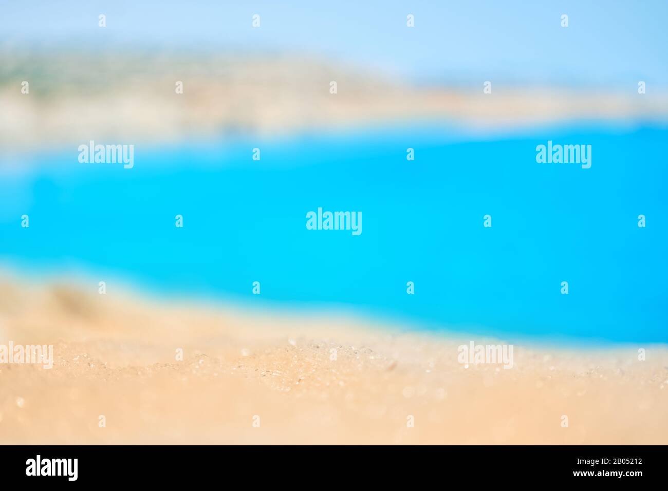 Abstract beach sand on a blurred beach background. Copy space. Close up ...