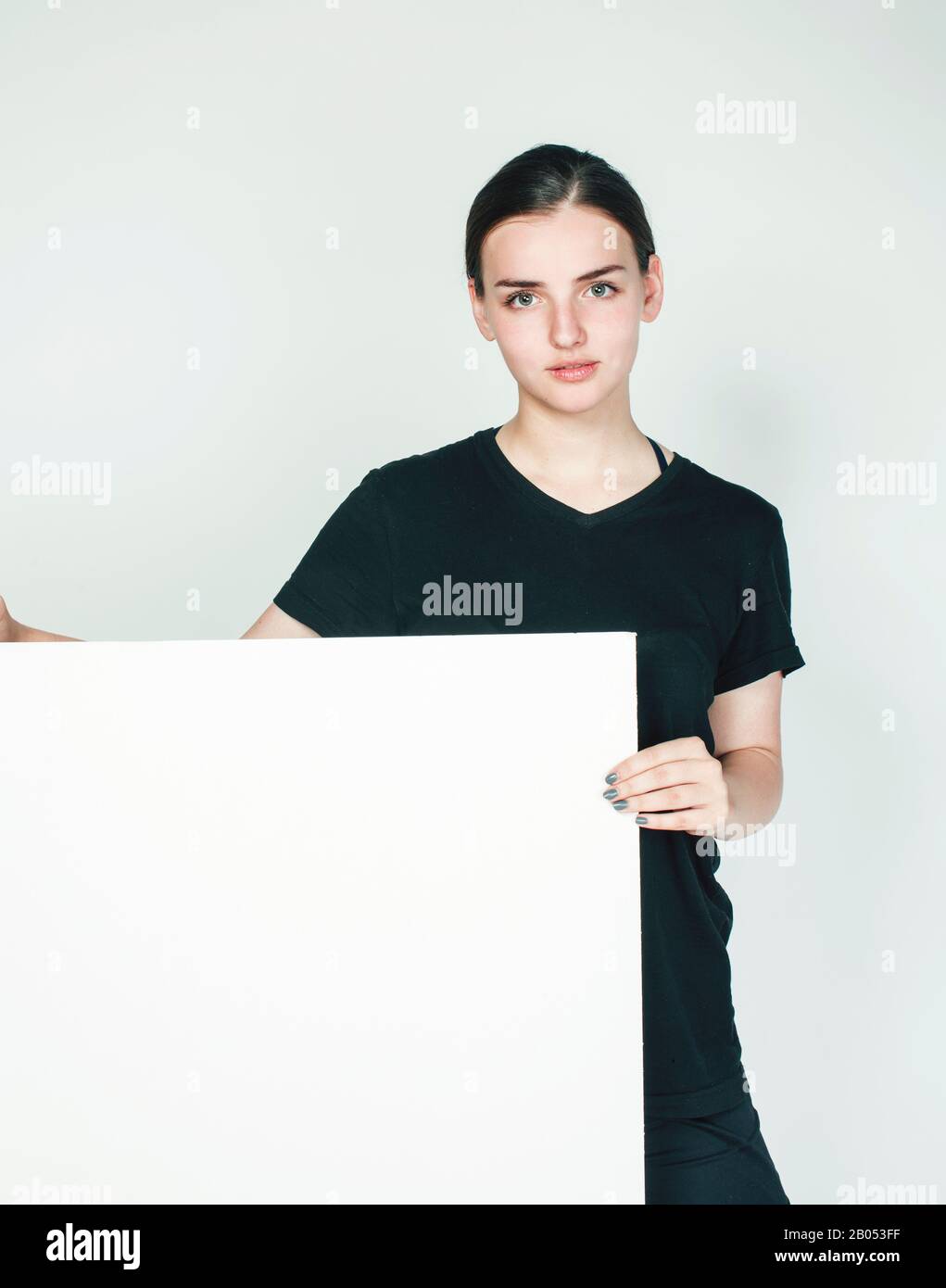 young pretty brunette girl with placard on white background wearing ...