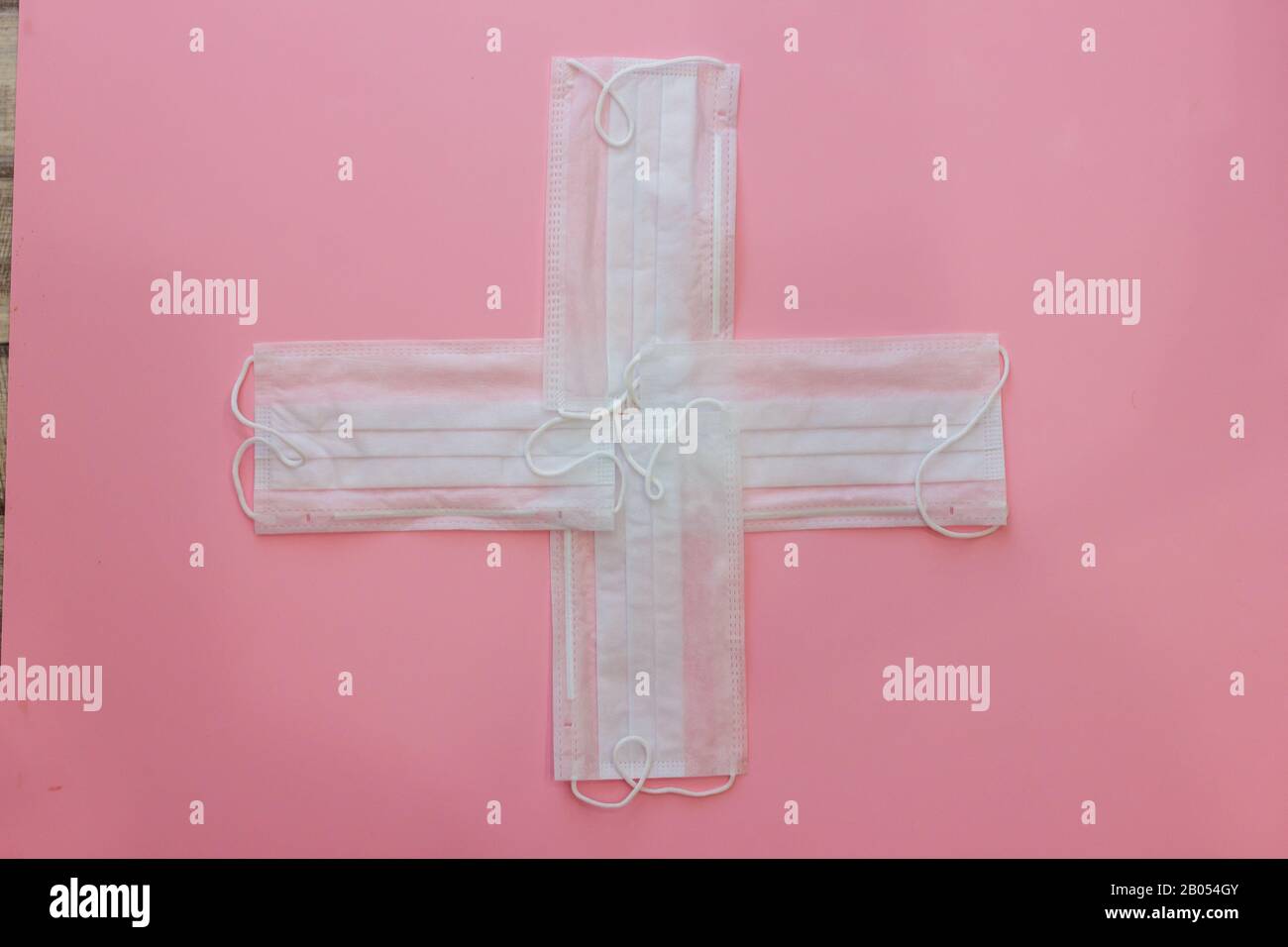 White cross shaped Medical masks on pink background Stock Photo - Alamy